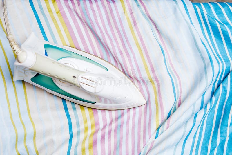 Photo of Iron on Striped Sheet in House Stock Photo - Image of female ...