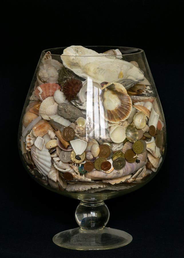 A Large Glass Container a Vase of Many Different Shells and Metal Coins ...