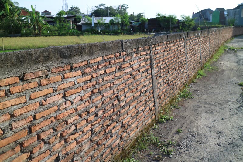 A Long Wall with Red Bricks on the Edge of a Rice Field Stock Photo ...