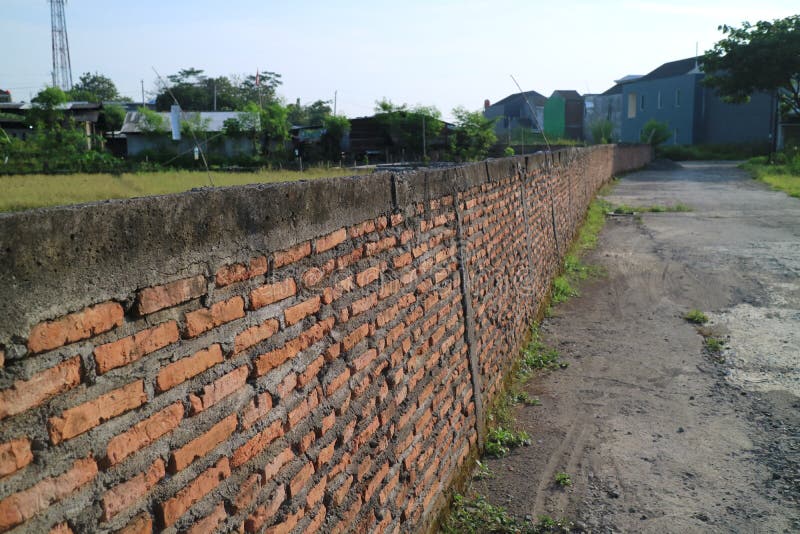 A Long Wall with Red Bricks on the Edge of a Rice Field Stock Photo ...