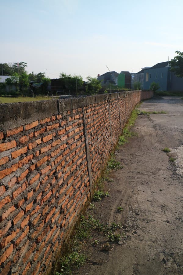 A Long Wall with Red Bricks on the Edge of a Rice Field Stock Photo ...