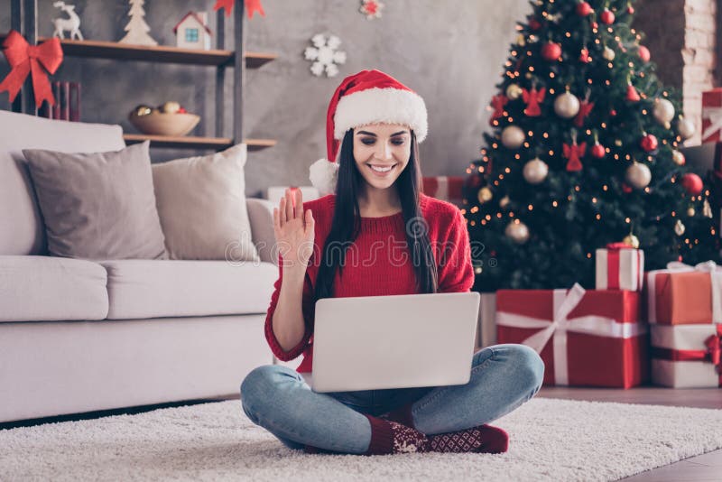 Photo Of Lovely Young Girl Sit Floor Hold Pc Waving Arm Wear Santa