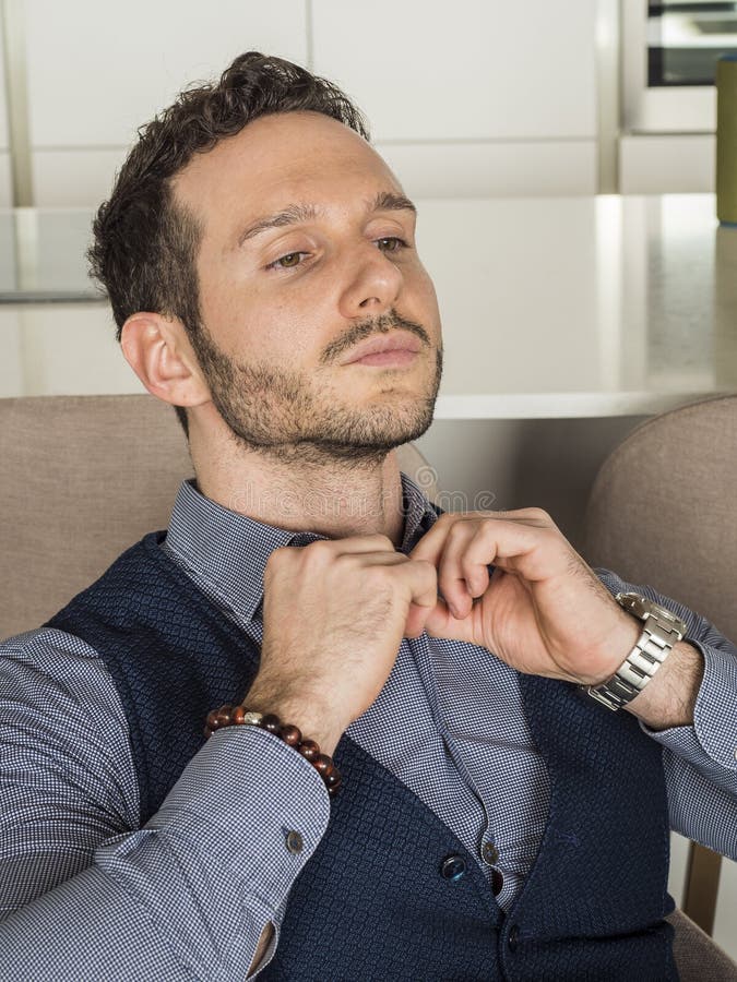 Photo of a Man Adjusting His Tie while Sitting in a Chair Stock Photo ...