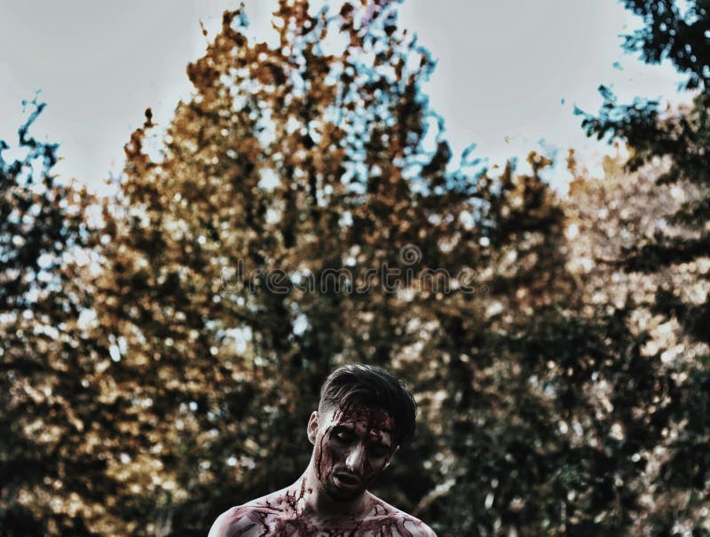 Photo Of Man Full Of Blood Near Trees Picture. Image: 114603105