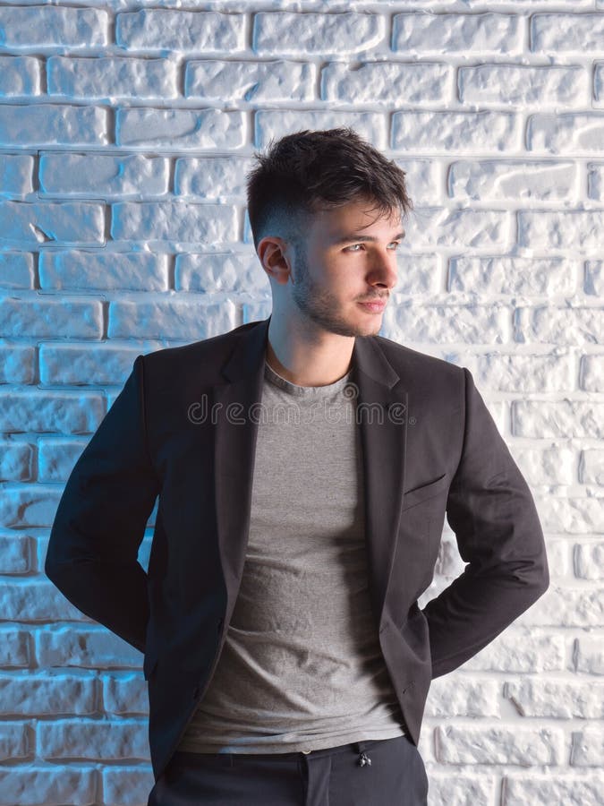 Photo of a Man Standing in Front of a White Brick Wall Stock Photo ...
