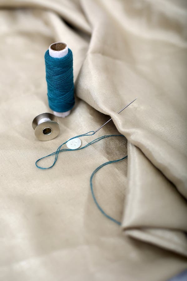 Photo of Needle Attached in Cloth with Blue Sewing Thread and Bobbin ...