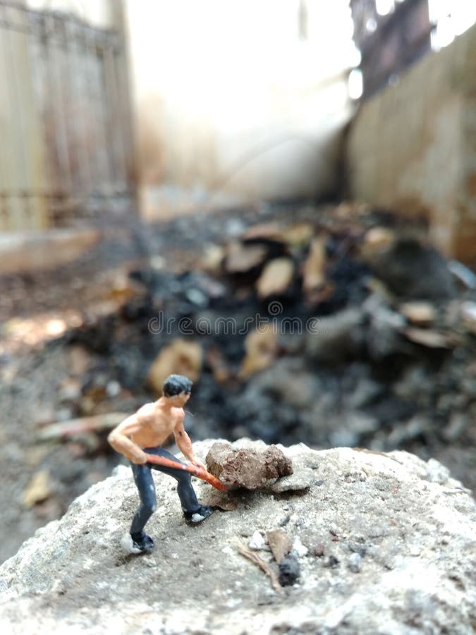 One Small Worker Lifting Stone Using Shovel in Front of Burned Trash ...