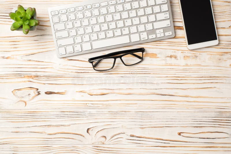 Photo Overhead of Keyboard Plant Phone and Glasses on the Wood Table ...