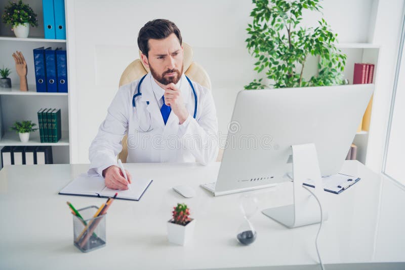 Photo of Serious General Practitioner Guy Sit Desk Write Copybook Look ...