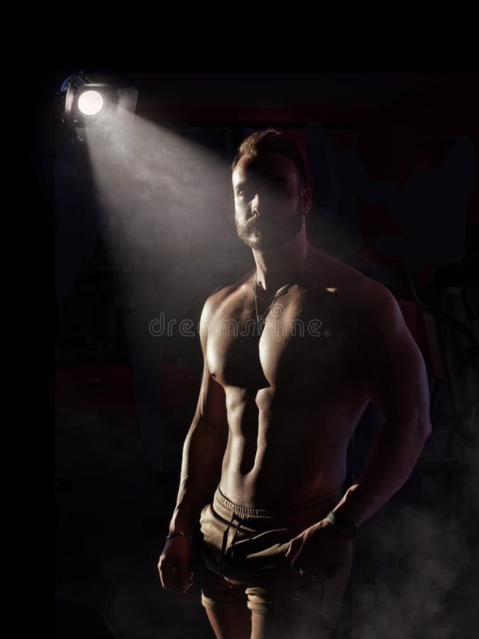 Photo of a Shirtless Man Standing in Front of a Spotlight Stock Image ...