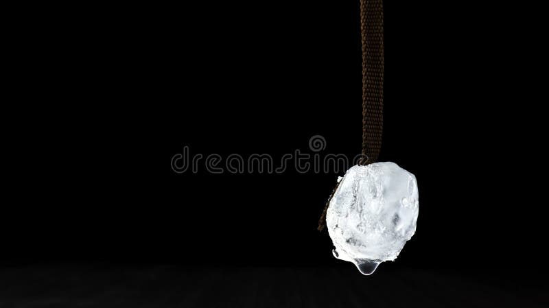 Ice Cube Attached To a Rope Stock Photo - Image of string, darkness ...