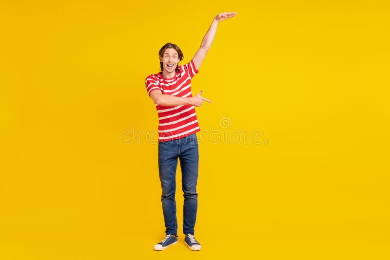 Photo Of Sweet Impressed Young Man Wear Striped T Shirt Measuring Size