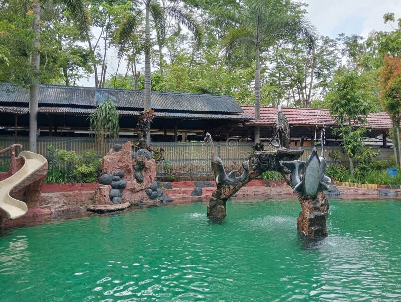 Photo of a Swimming Pool with a Fish Statue Above it Stock Photo ...