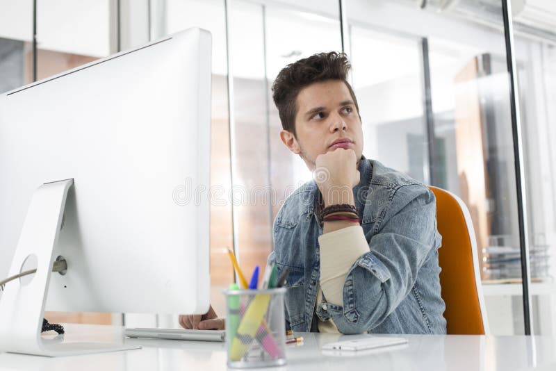 Thoughtful Businessman Sitting while Using Computer in Office Stock ...