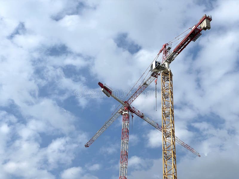 A Photo of Three Cranes Working Together on the Construction Site Stock ...
