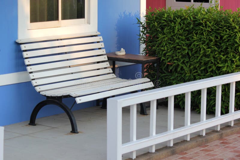 White Bench and Table in Front of Blue House Stock Image - Image of ...
