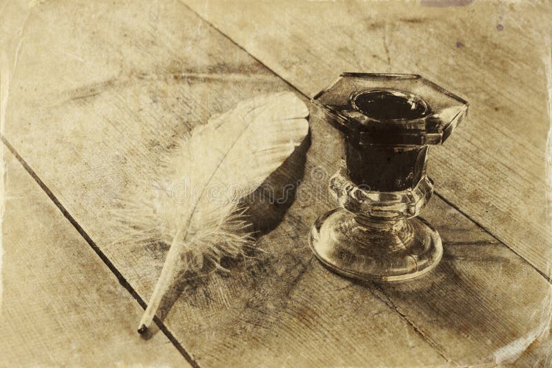 Photo of White Feather and Inkwell on Old Wooden Table Stock Photo ...