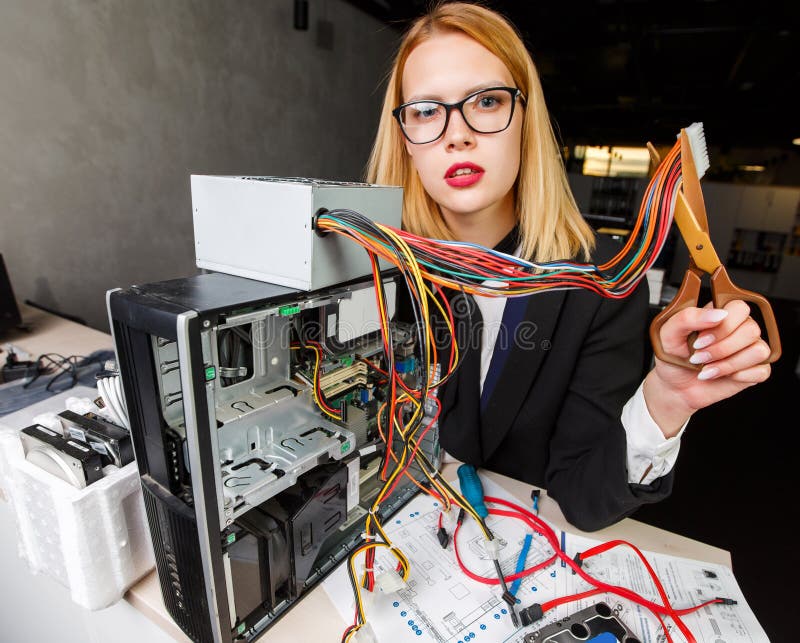 Photo of Woman in Glasses at Table with Broken Processor and Laptop ...