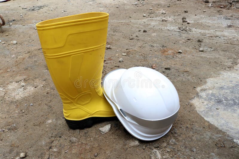 Photo of Yellow Rubber Boots and Safety Helmets Stock Photo - Image of ...