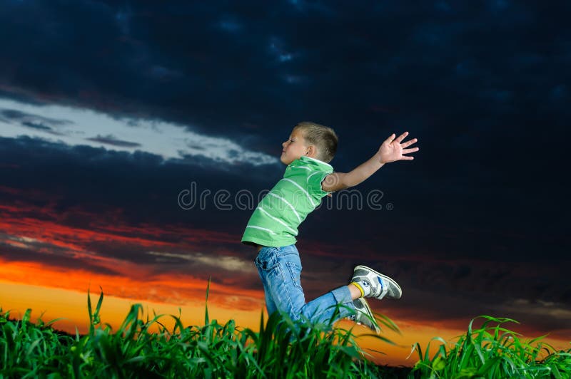 Photo of Young Boy Jumping and Raising Hands Stock Image - Image of ...