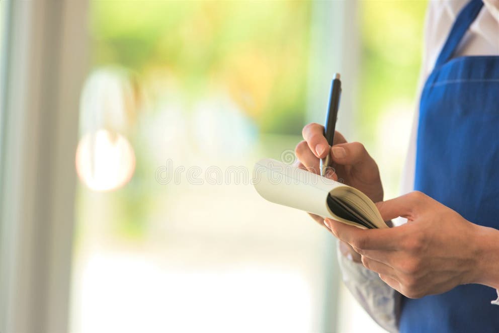 Young Confident Waitress Writing on Notepad at Restaurant Stock Photo ...