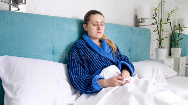 Image of Young Woman in Bathrobe Feeling Sick Lying in Bed Stock Photo ...