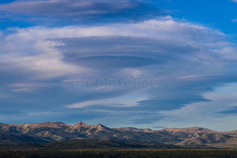 Cloudy Sky and a Large Lenticular Cloud Over Mountain Peaks. Stock ...