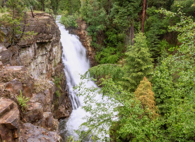 Dreamy Waterfall in Green Forest with Rock Bluff Stock Image - Image of ...