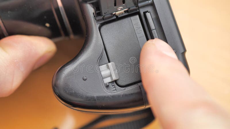 A Photographer Changes the Battery in His Digital SLR Camera while ...