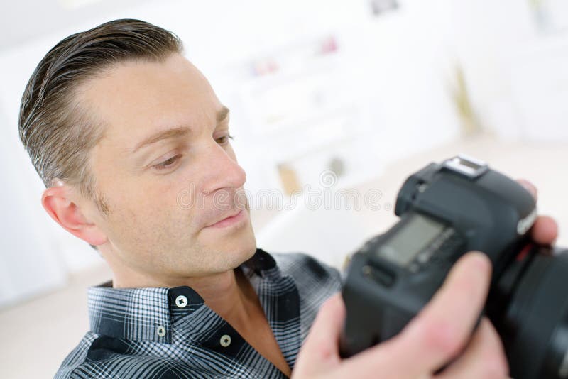 Photographer Checking Camera Indoors Stock Image - Image of photograph ...