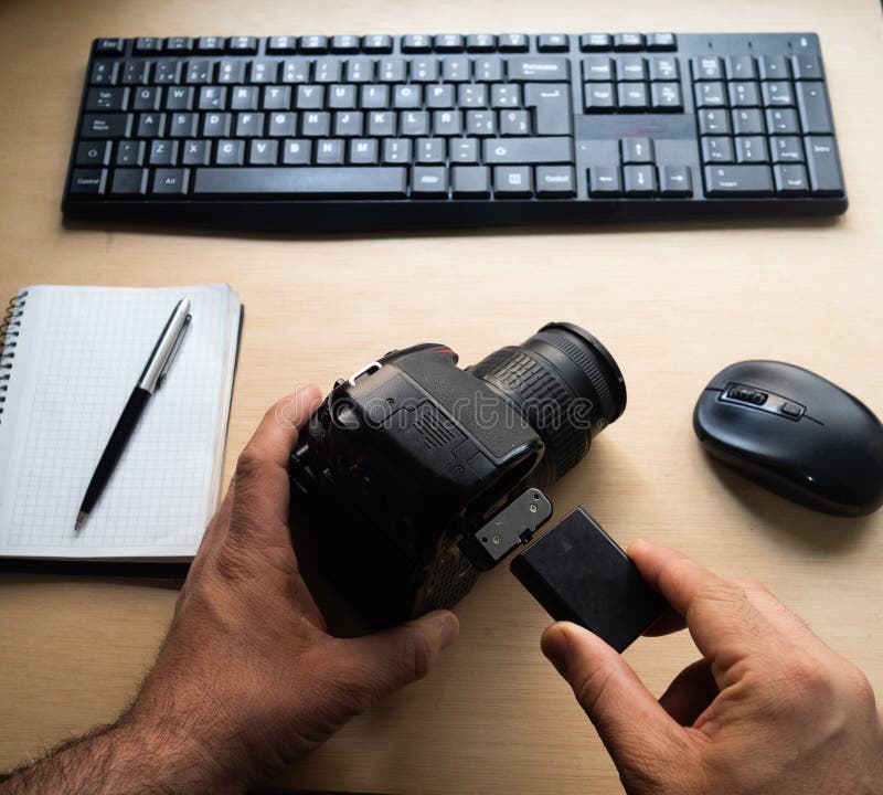 Photographer Checking the Camera with Keyboard, Mouse, and Notebook on ...