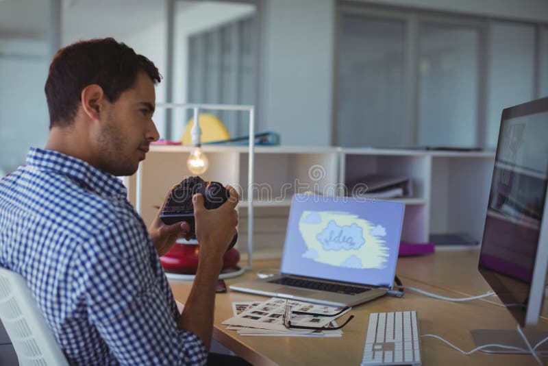 Photographer Holding Camera while Sitting in Creative Office Stock ...