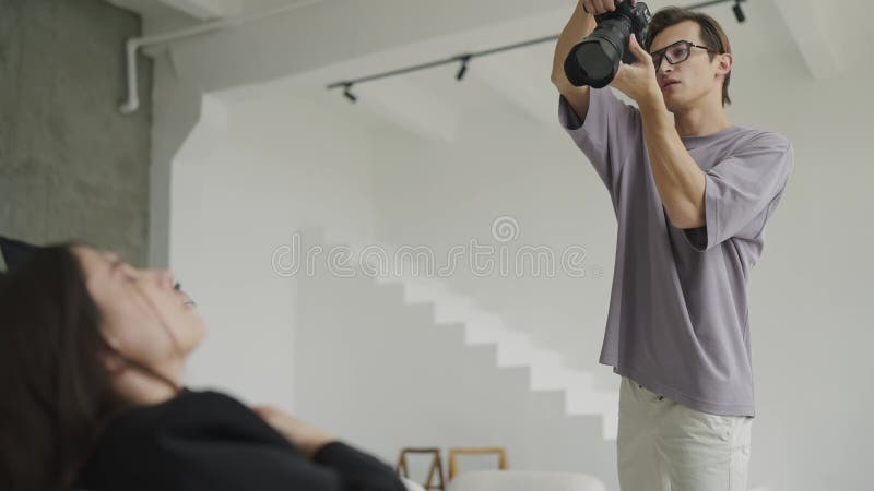 Photographer Photographs Model from an Upper Angle in Bright Studio in ...