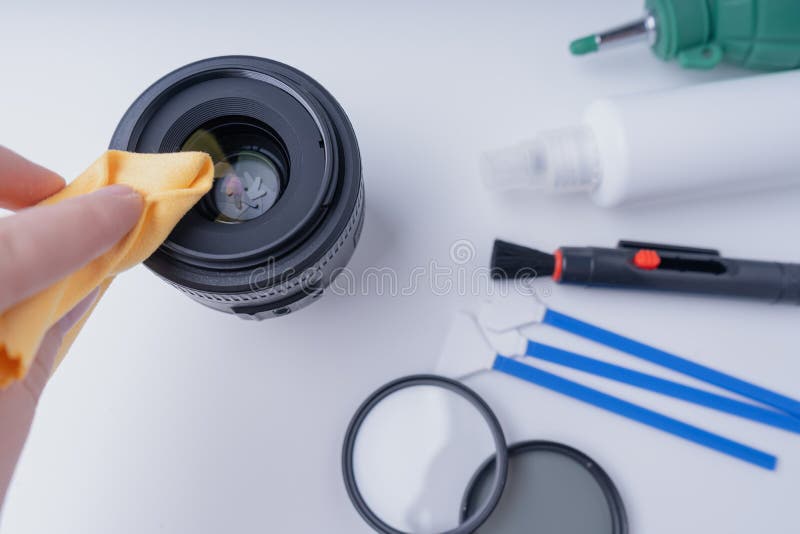 The Photographer`s Hand with Yellow Microfiber Wipes the Camera Lens ...