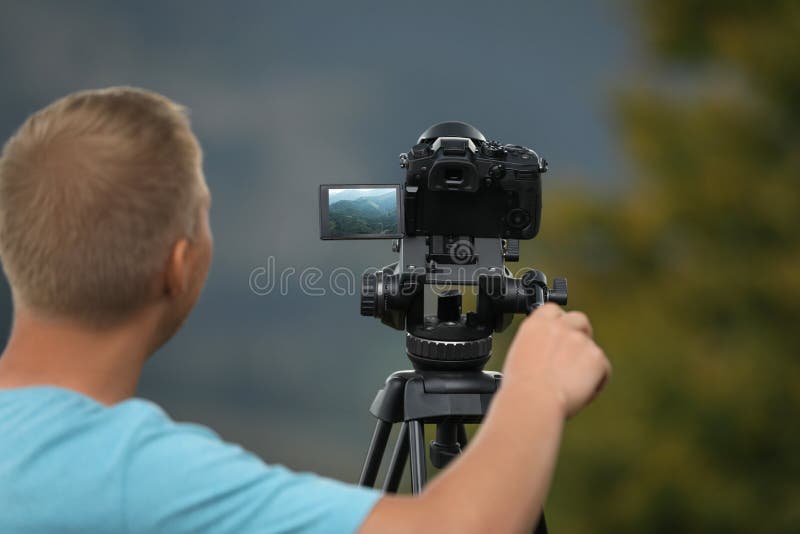 Photographer Taking Video with Modern Camera on Tripod in Nature Stock ...