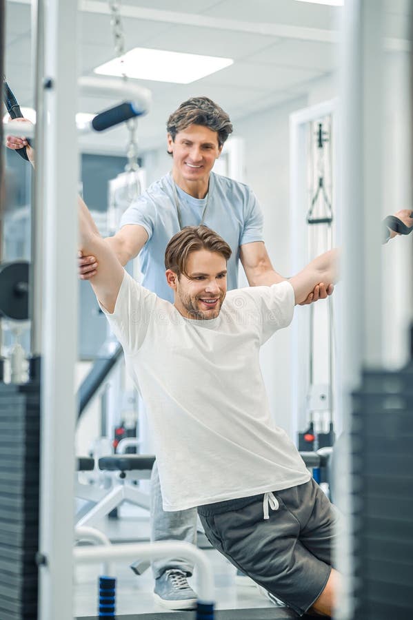 Physical Therapist Assisting a Patient while Exercising on ...