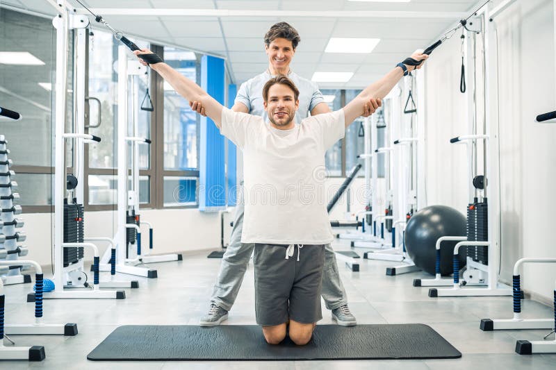Physical Therapist Assisting a Patient while Exercising on ...