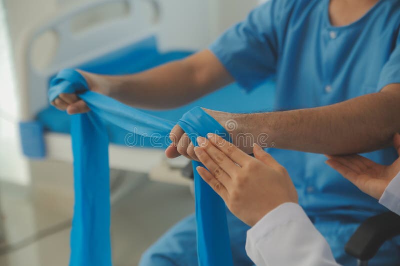 Physical Therapist Guiding Patient with Resistance Band Stock Photo ...