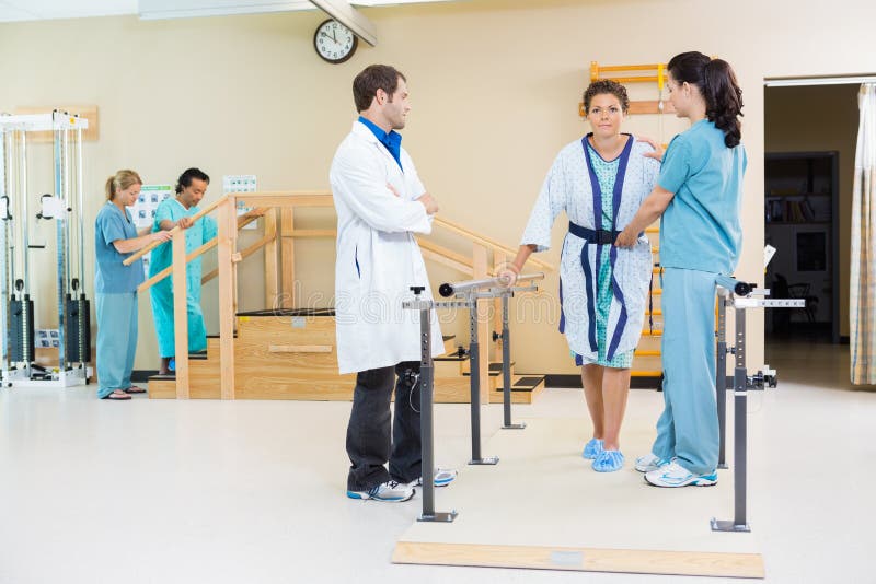 Physical Therapists Assisting Female Patient in Stock Image - Image of ...