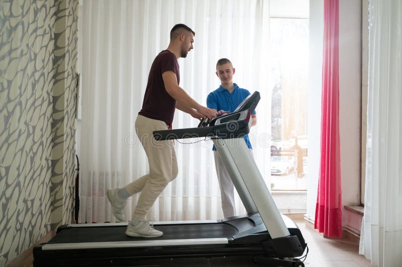 Physical Therapy on Treadmill.Man Undergoing Physical Therapy with ...