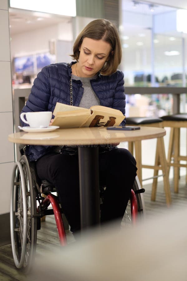 Physically Challenged Woman Reading in a Cafe Stock Photo - Image of ...