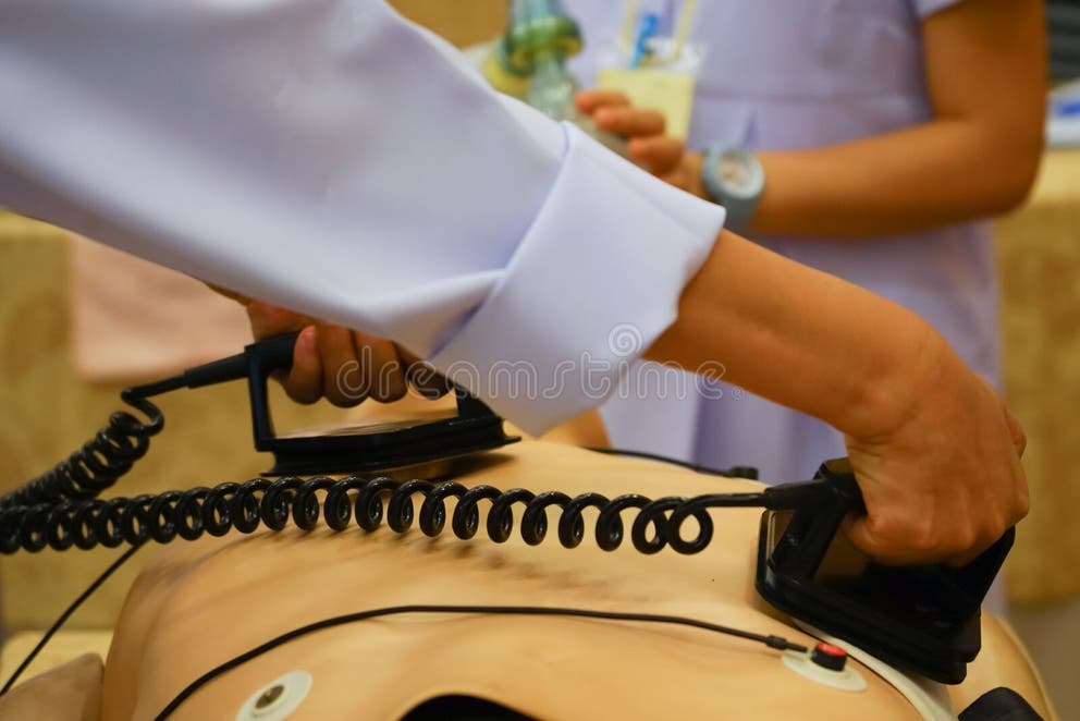 A Physician Perform Defibrillation on a CPR Doll Stock Photo - Image of ...