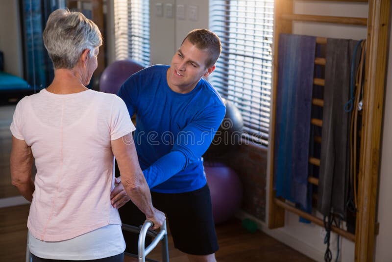 Physiotherapist Assisting Patient To Walk with Walking Frame Stock ...