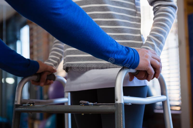 Physiotherapist Assisting Patient To Walk with Walking Frame Stock ...