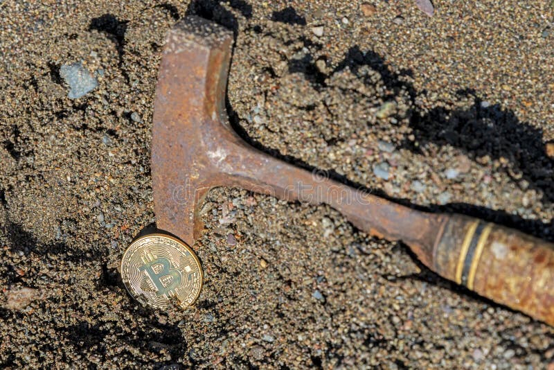 A Pick Axe Digging a Bitcoin Out of Sandy Ground Stock Photo - Image of ...