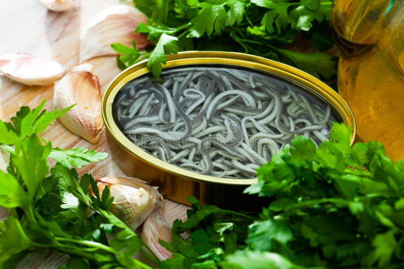 Pickled Eels in Open Tin Can with Garlic at Table Stock Photo - Image ...