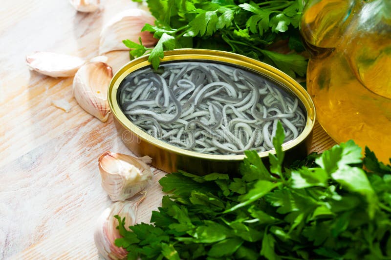 Pickled Eels in Open Tin Can with Garlic at Table Stock Photo - Image ...