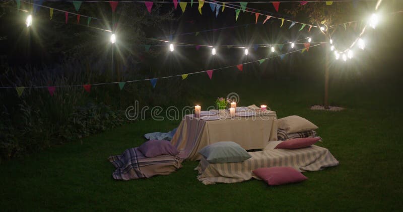 A Picnic Table Decorated with Candles, Illuminated by Hanging String ...