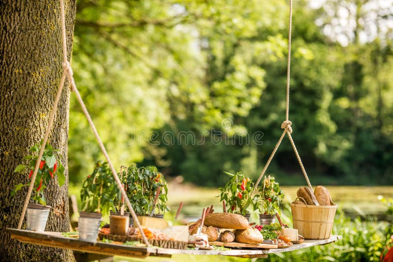 Picnic Table Hanging from a Tree with Bread, Cheese, and Dishes, in a ...