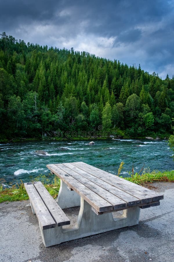 A Picnic Table beside a River Flowing through a Forest in Lapland Under ...